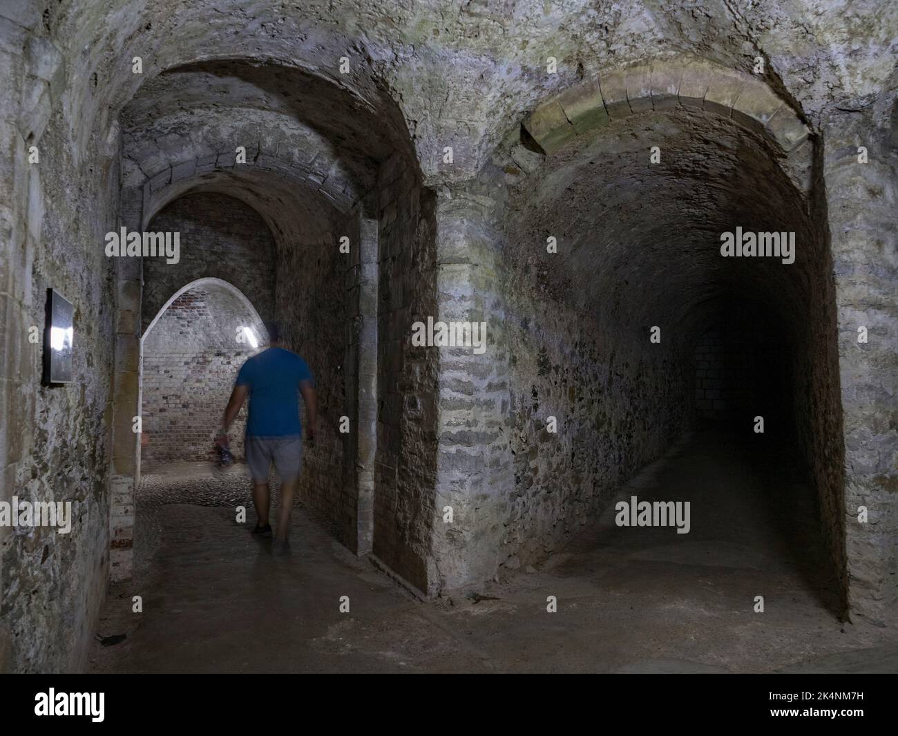 Visitor inside the medieval tunnels under Dover Castle, Kent, UK Stock ...