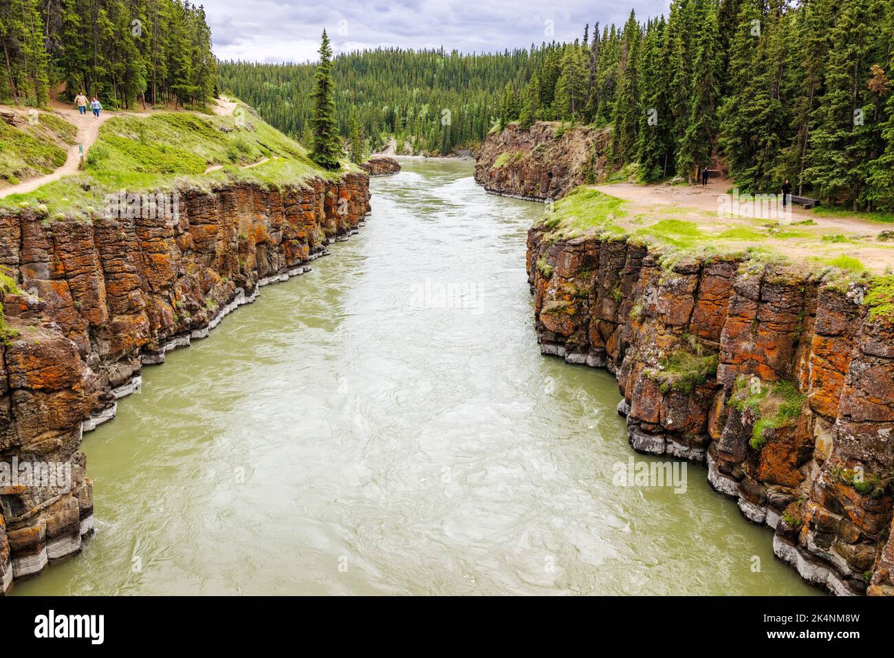 Tourists explore basalt rock formations; Miles Canyon; Whitehorse ...