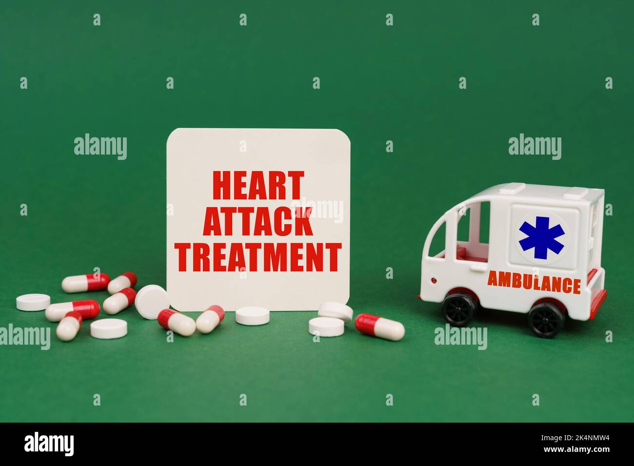 Medical concept. On a green surface, an ambulance, pills and a sign ...