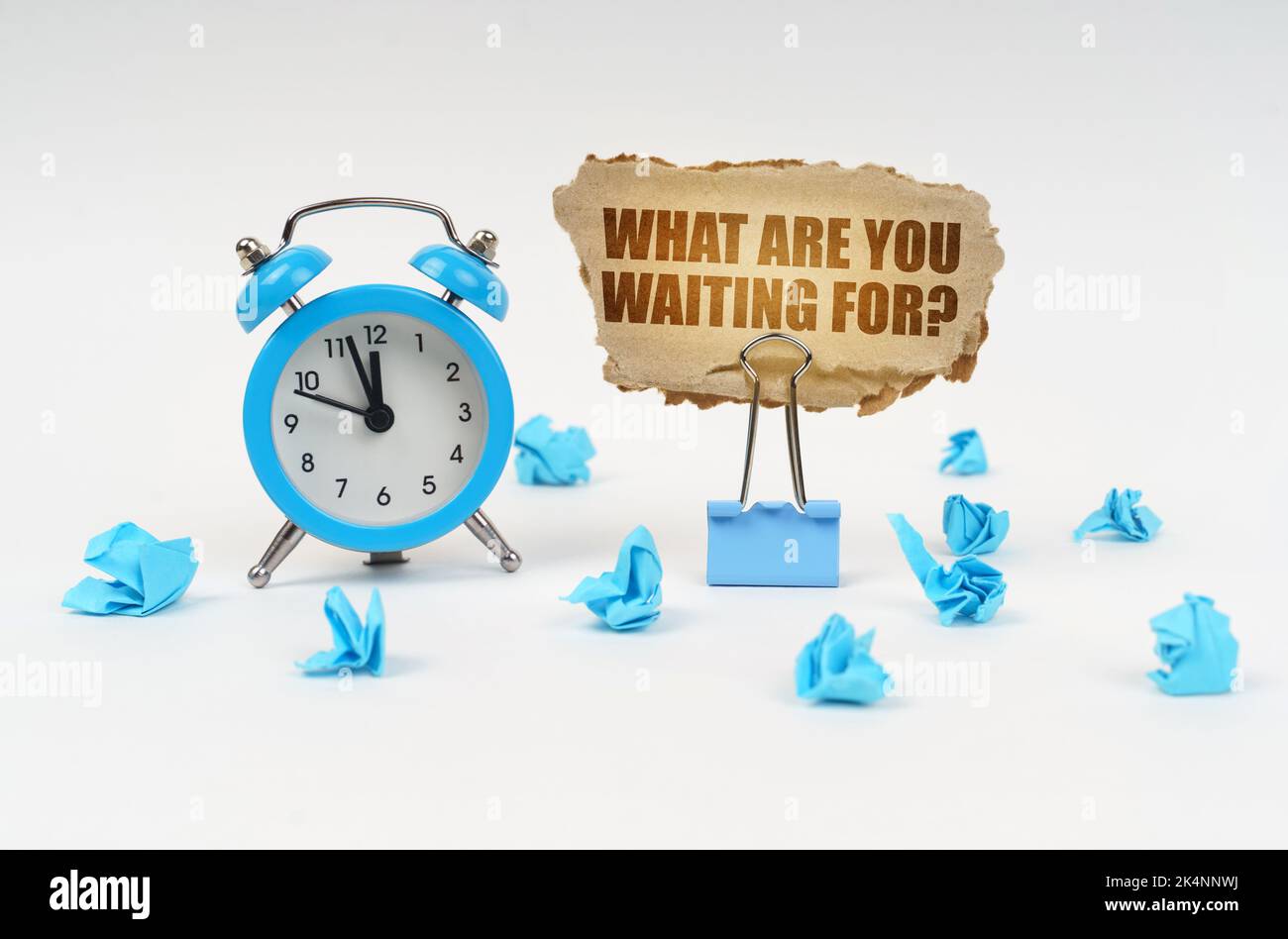 Time concept. On a white surface, an alarm clock, an office clip ...