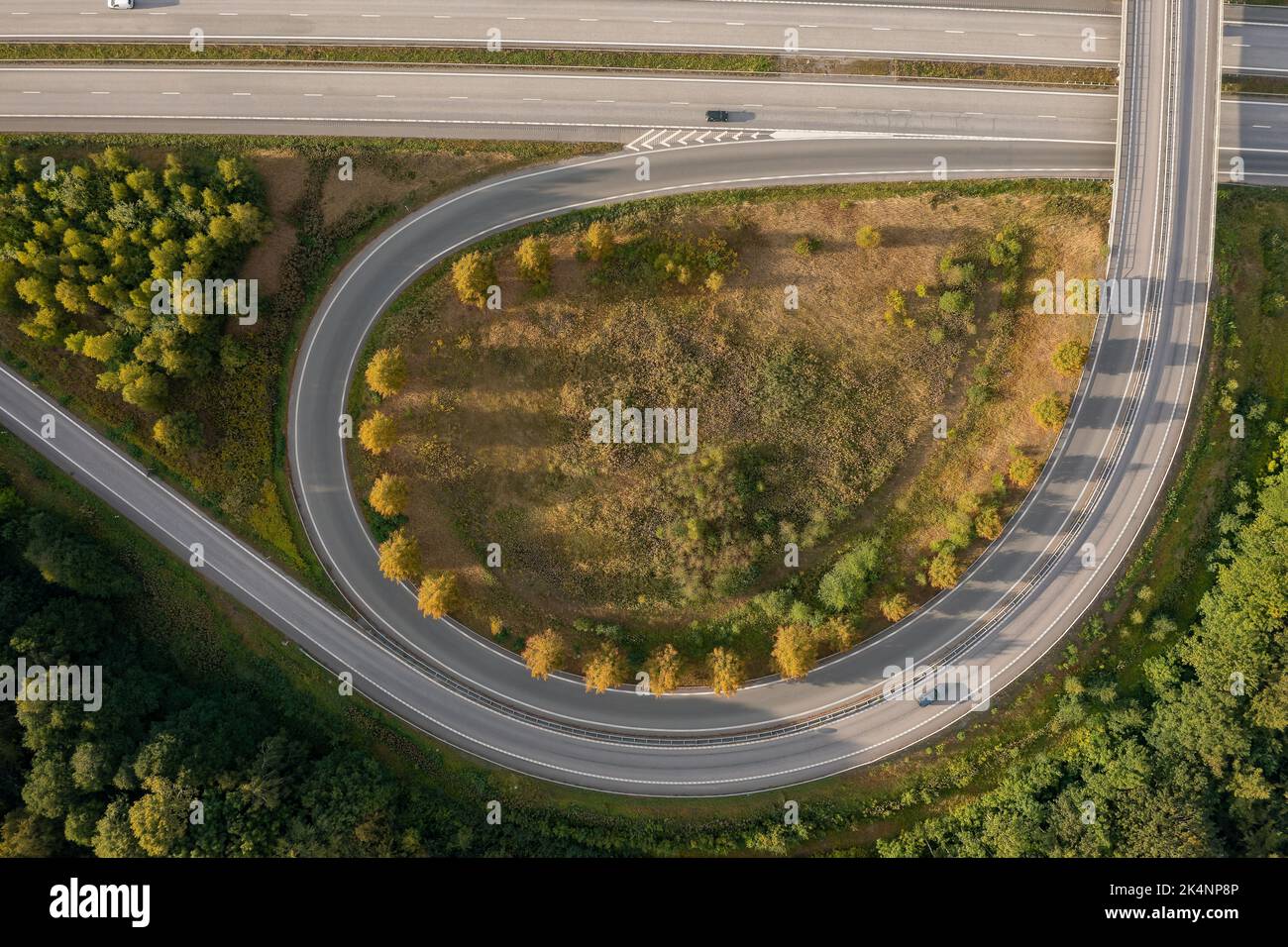 An aerial shot of a curved highway surrounded by dense vegetation Stock ...