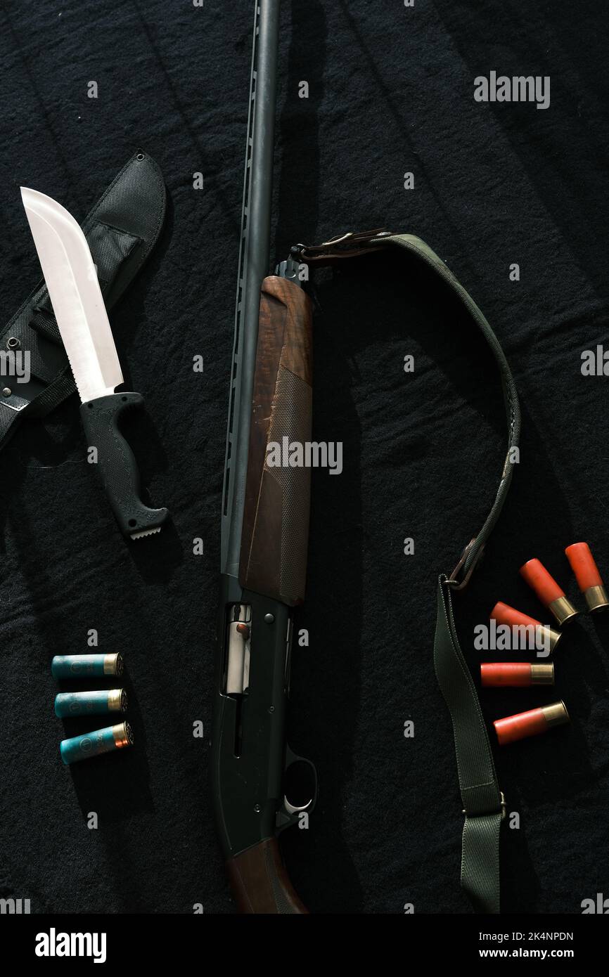 Weapon on black cloth: knife, rifle, shells,top view. Top view of knife ...