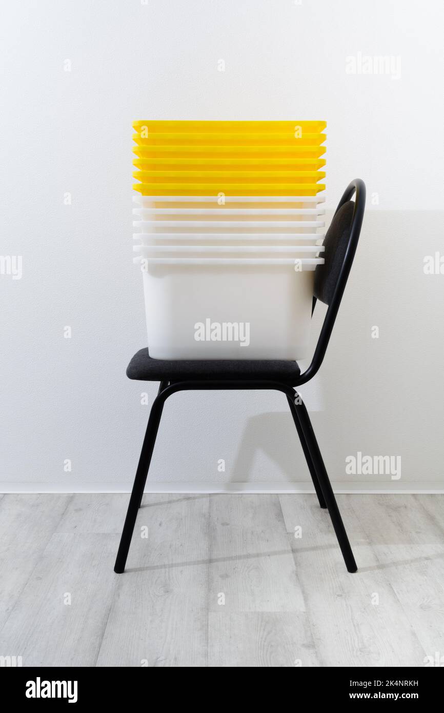 Yellow and white plastic containers on black office chair at home near ...