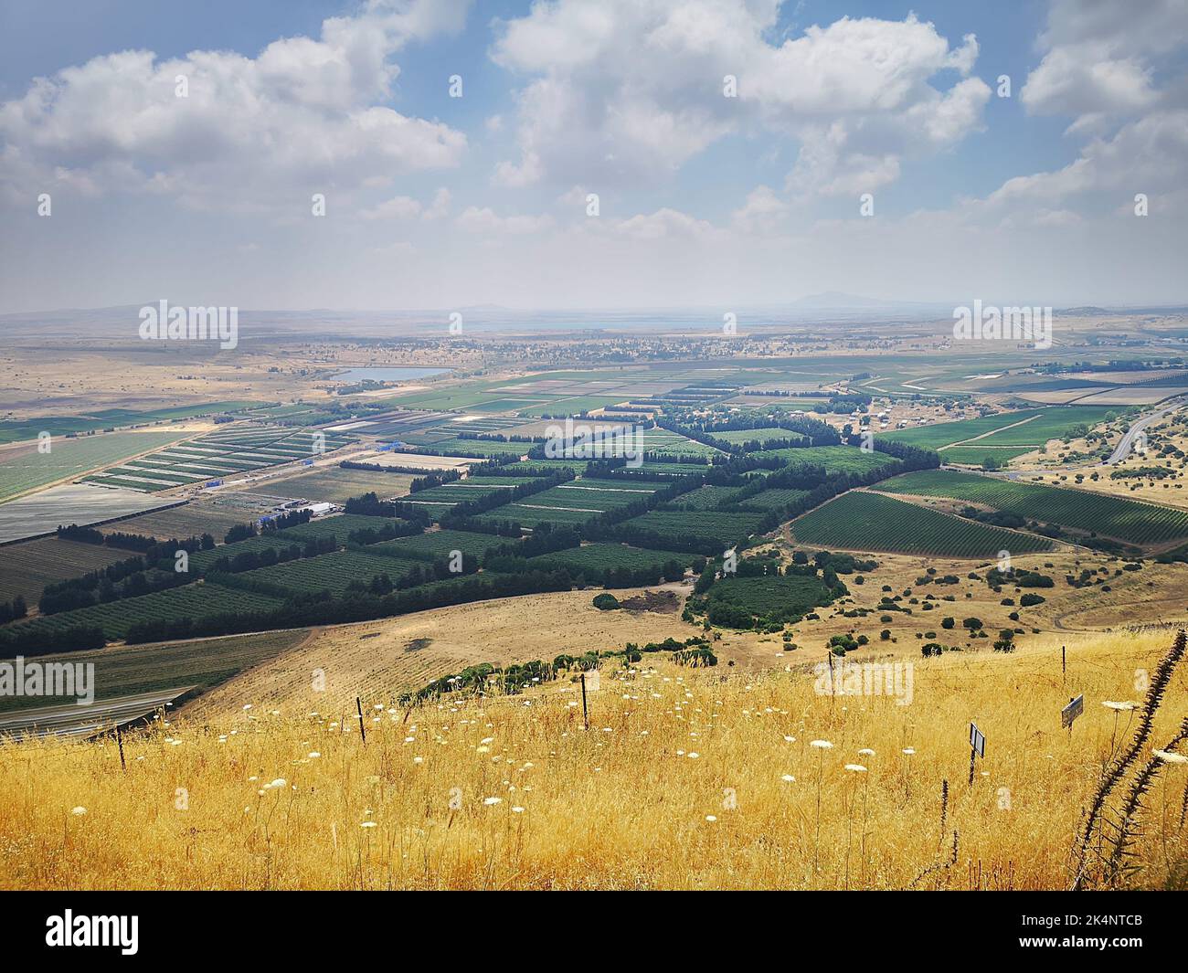 A beautiful shot of mountains and green fields under a blue cloudy sky ...