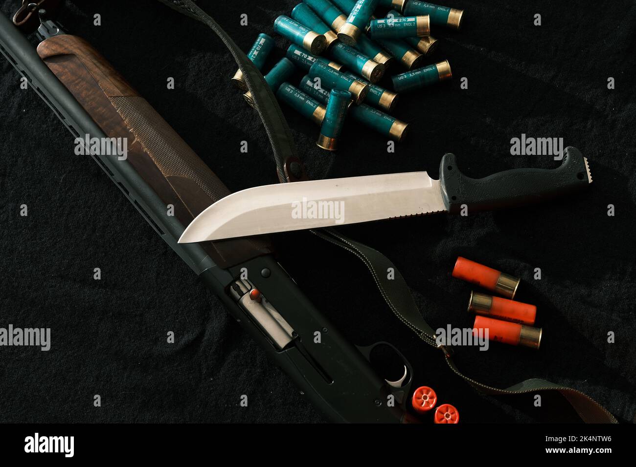 Weapon on black cloth: knife, rifle, shells,top view. Top view of knife ...