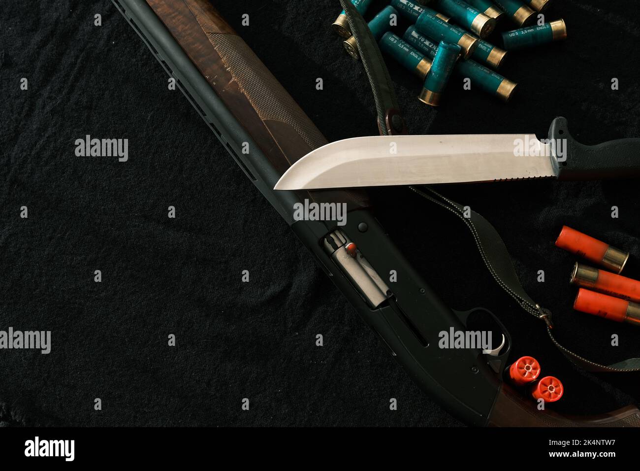 Weapon on black cloth: knife, rifle, shells,top view. Top view of knife ...