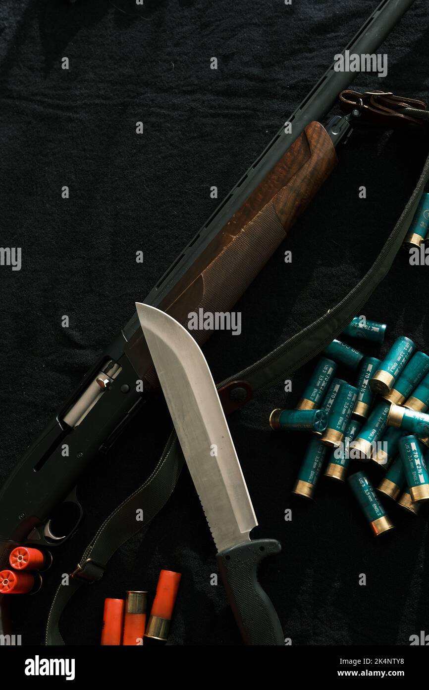 Weapon on black cloth: knife, rifle, shells,top view. Top view of knife ...