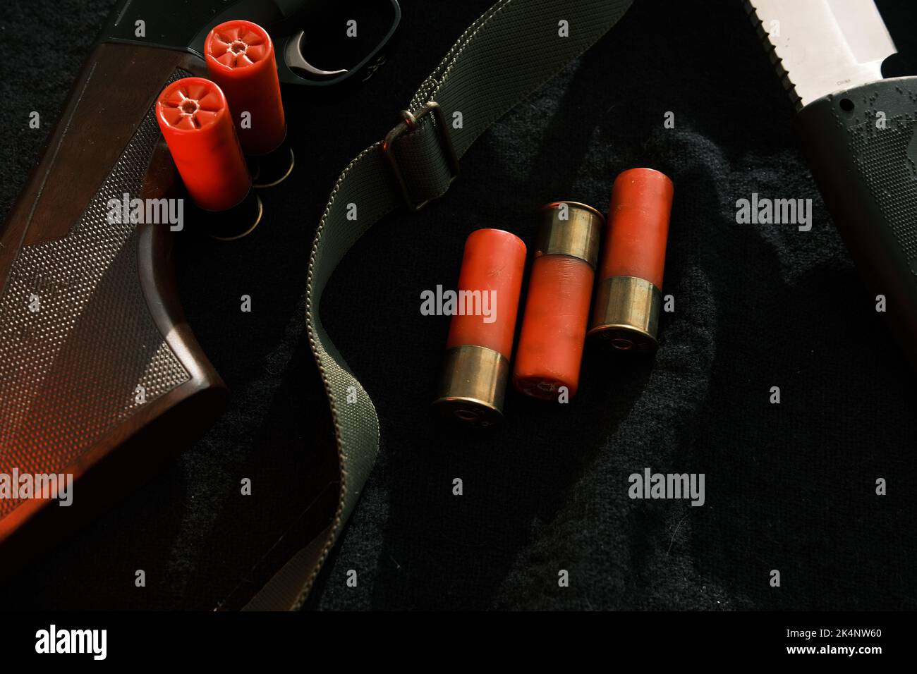 Weapon on black cloth: knife, rifle, shells,top view. Top view of knife ...