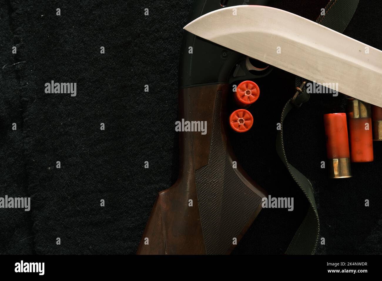 Weapon on black cloth: knife, rifle, shells,top view. Top view of knife ...
