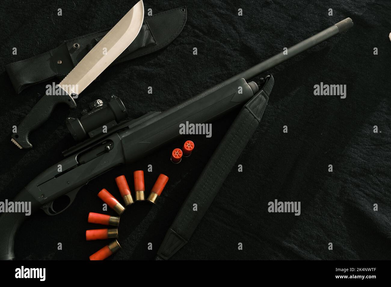 Weapon on black cloth: knife, rifle, shells,top view. Top view of knife ...
