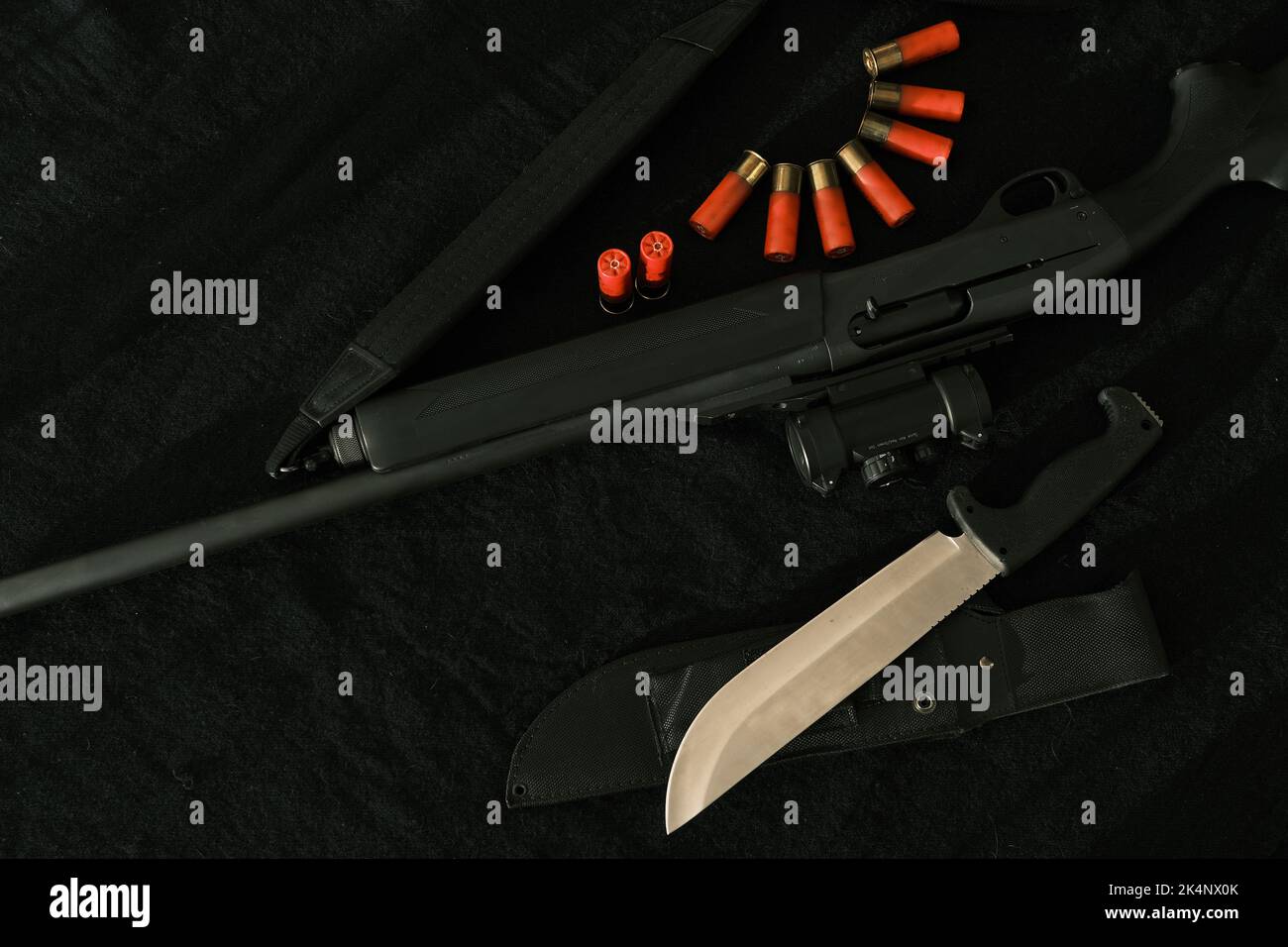 Weapon on black cloth: knife, rifle, shells,top view. Top view of knife ...