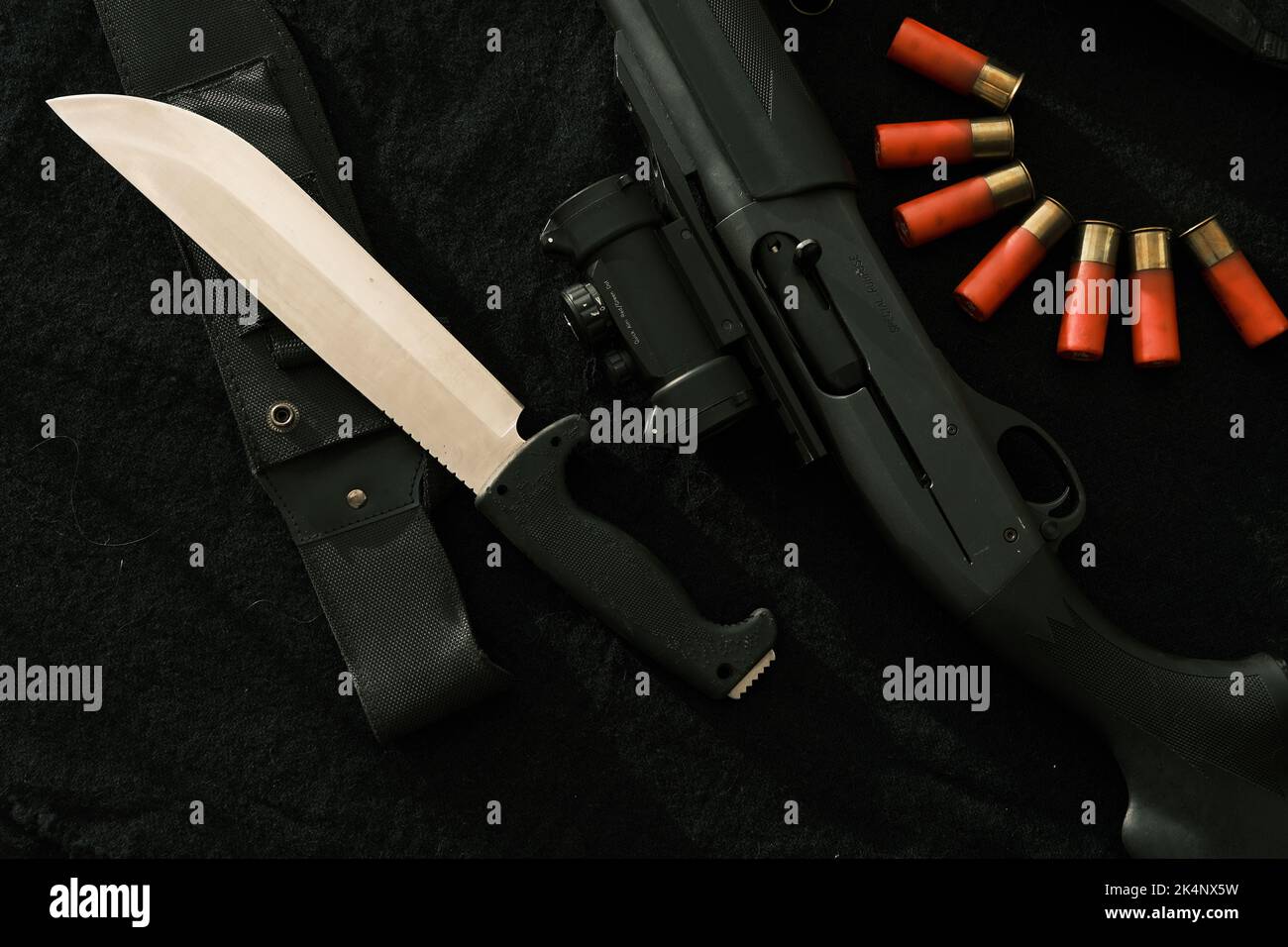 Weapon on black cloth: knife, rifle, shells,top view. Top view of knife ...