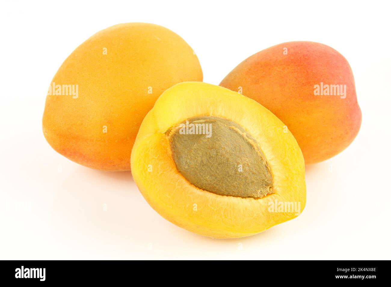 Whole and sliced apricots with visible core seed isolated on white ...