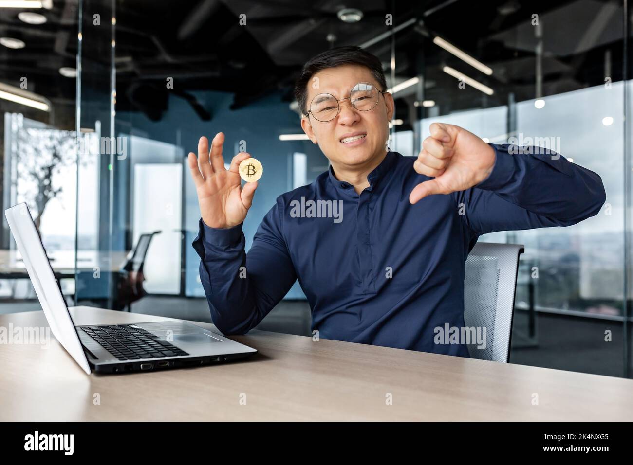 Dissatisfied asian businessman holding finger down, bad losing gesture ...