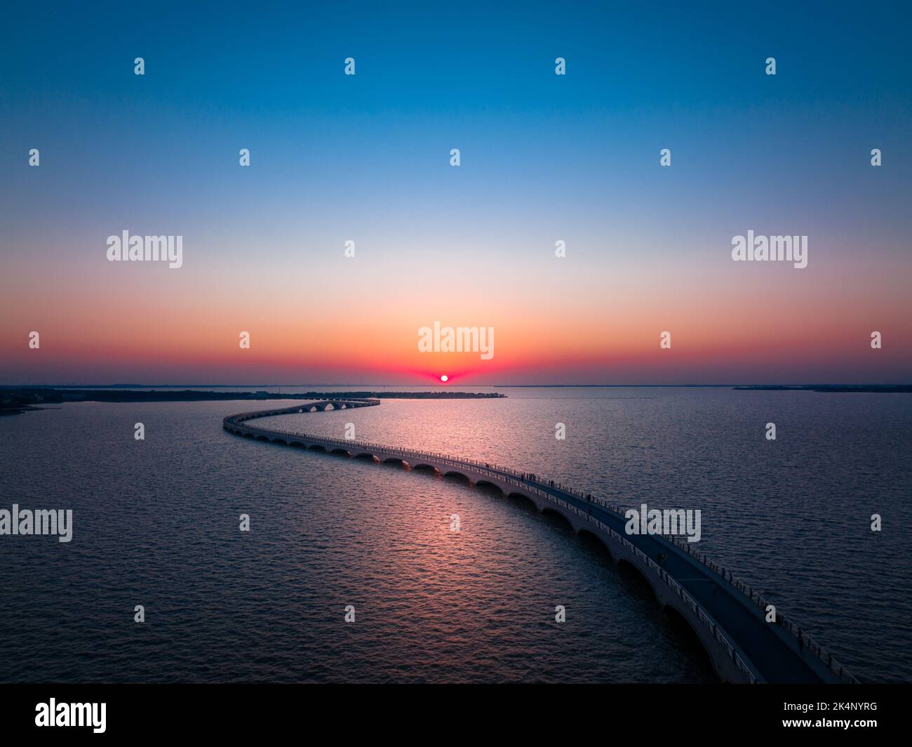 A high-angle shot of a bright pink sunset on the horizon with curvy ...
