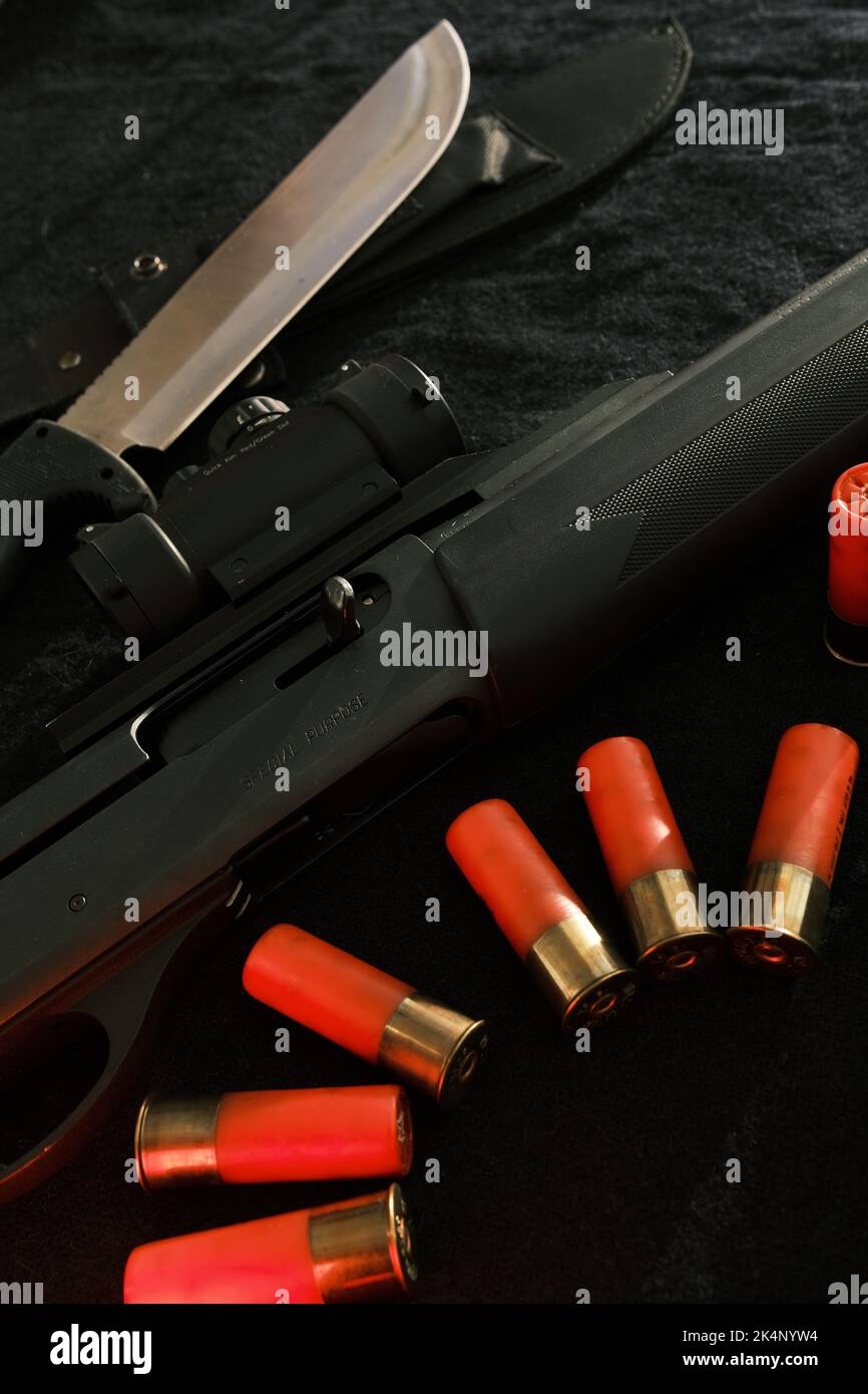 Weapon on black cloth: knife, rifle, shells,top view. Top view of knife ...