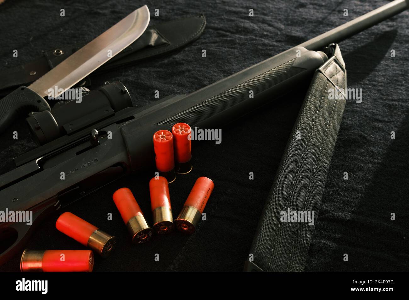 Weapon on black cloth: knife, rifle, shells,top view. Top view of knife ...