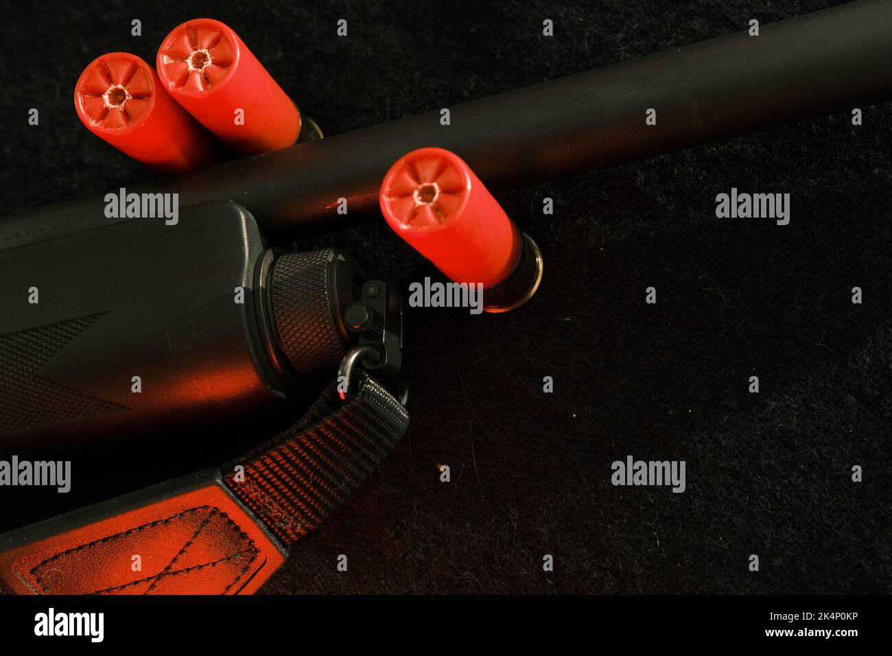 shell magazine into the barrel of a long shotgun on dark background ...