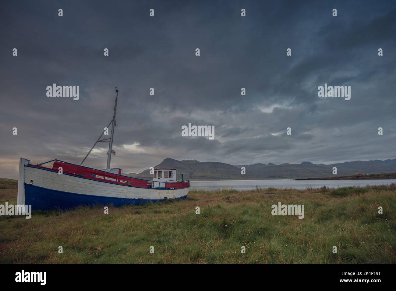 Red, white and blue sail boat marooned in Iceland Stock Photo - Alamy