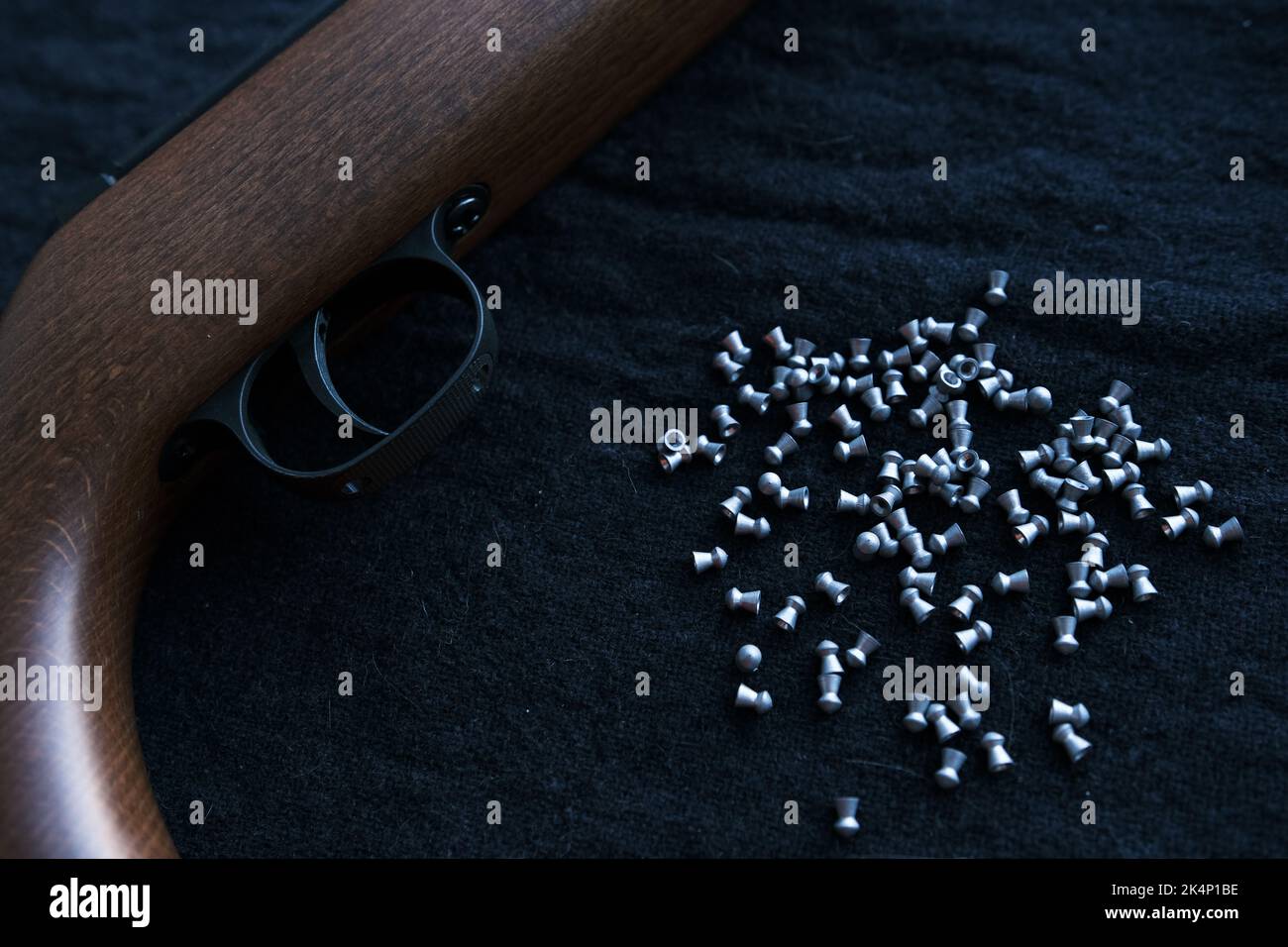 Rifle gun trigger with air pellets for hunting on cloth dark background ...