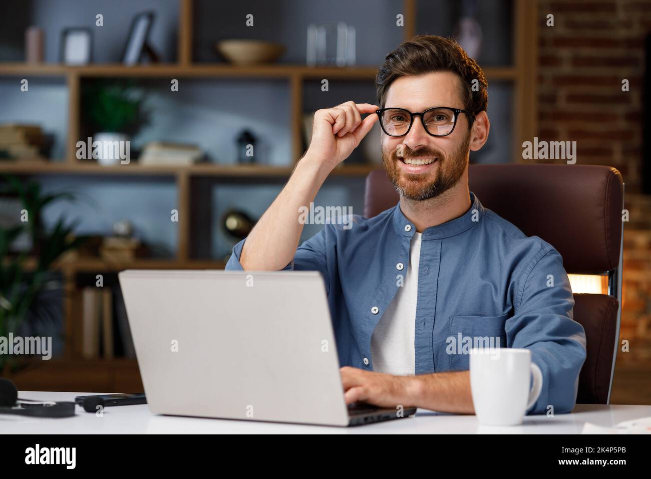Handsome male businessman manager working behind a laptop in a stylish ...