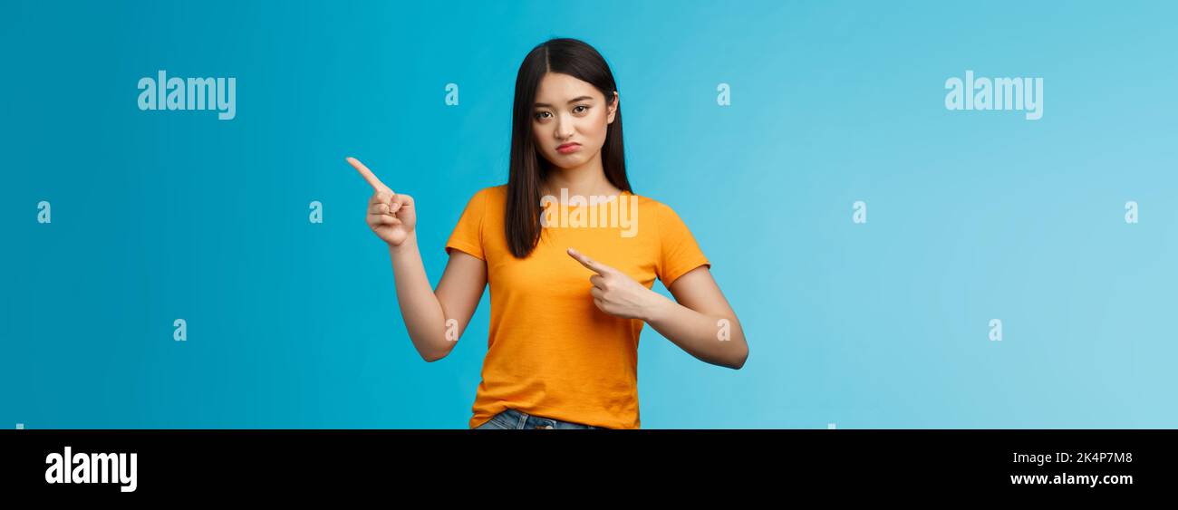 Picky disappointed asian girl with unsatisfied face, pointing upper ...