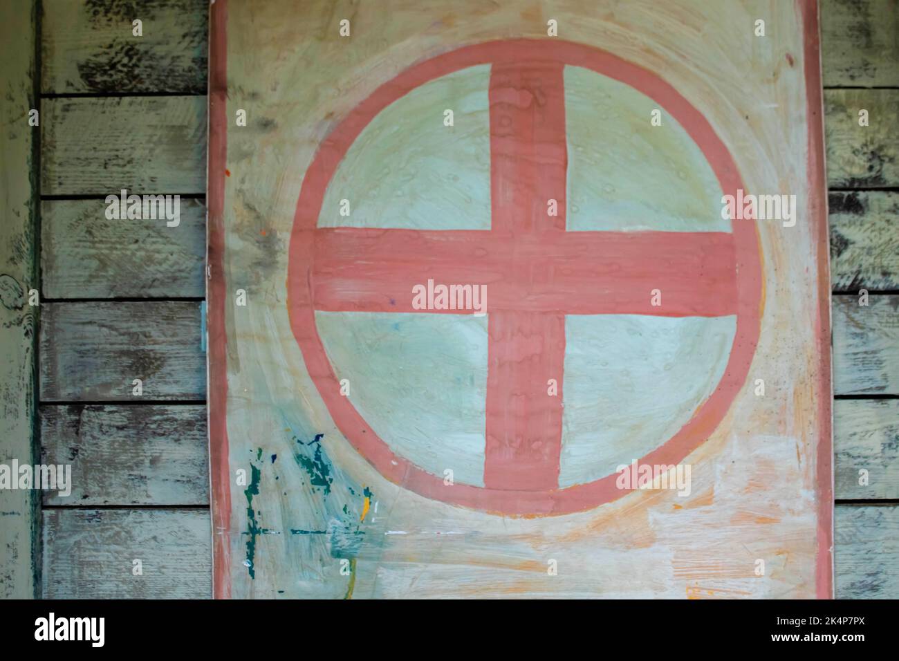 Red cross of the hospital, on the brick wall of the building, In a gray ...