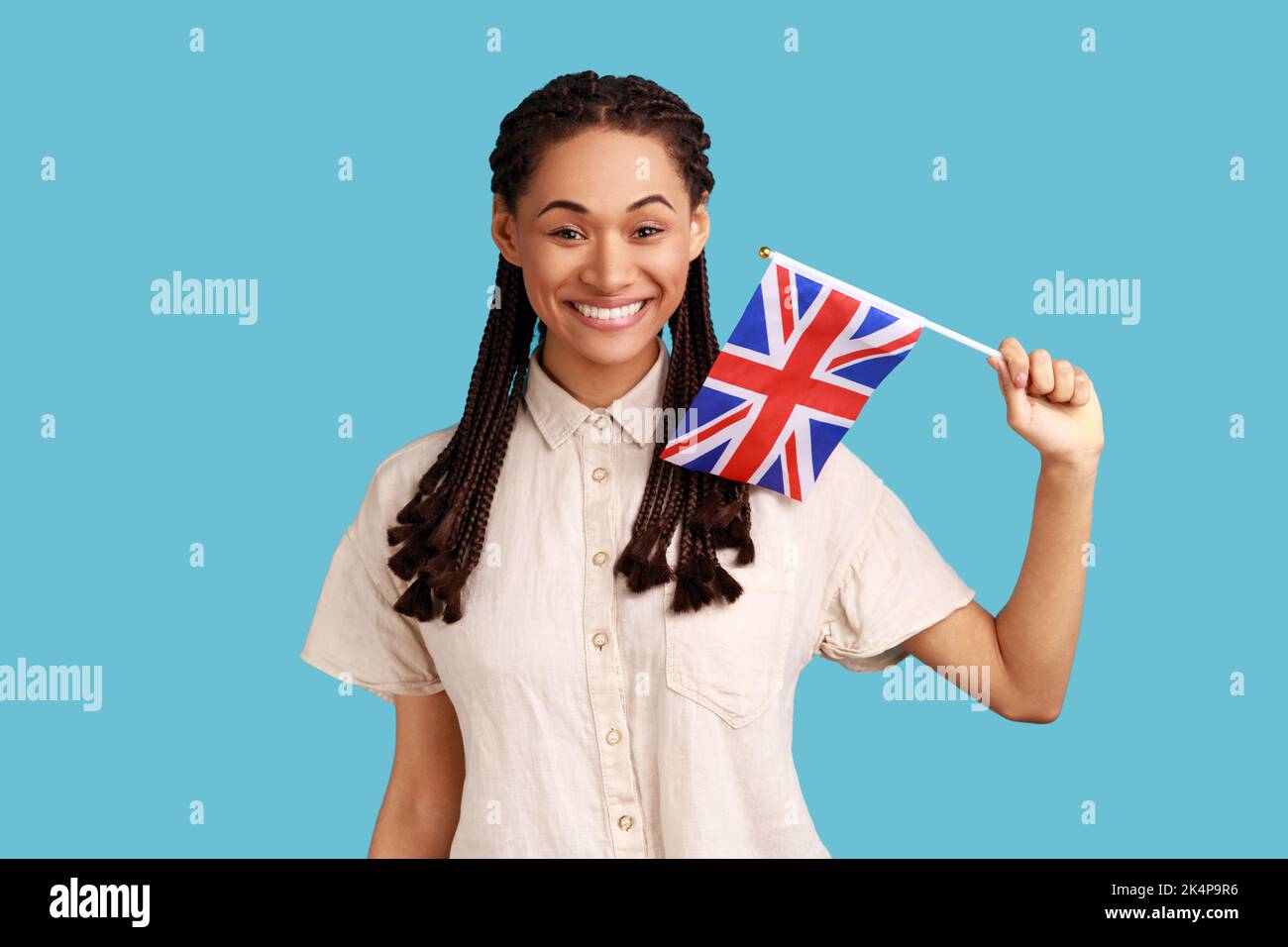 Portrait of smiling satisfied woman with black dreadlocks holing ...