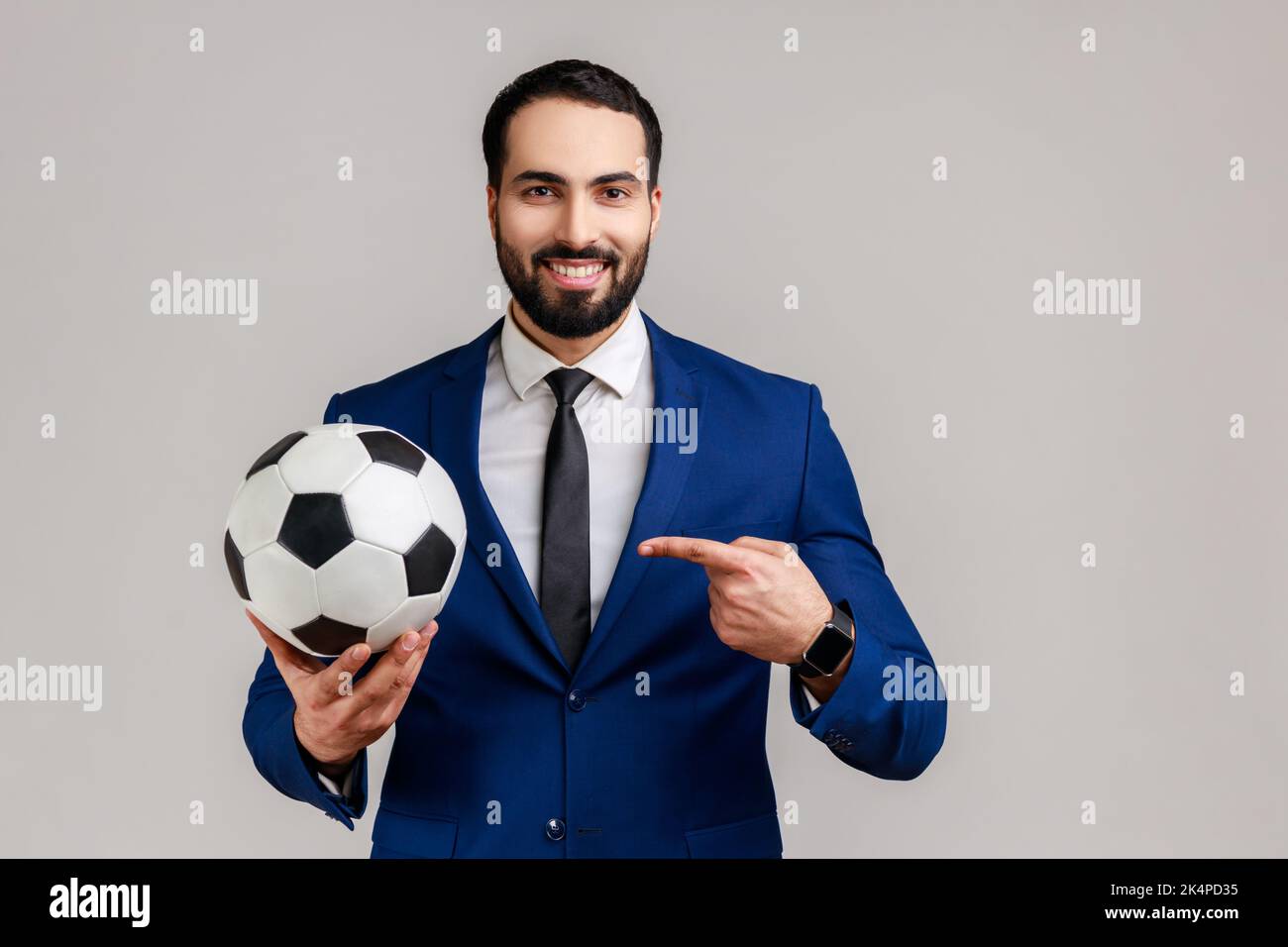 Handsome bearded businessman pointing finger at soccer ball on his hand ...