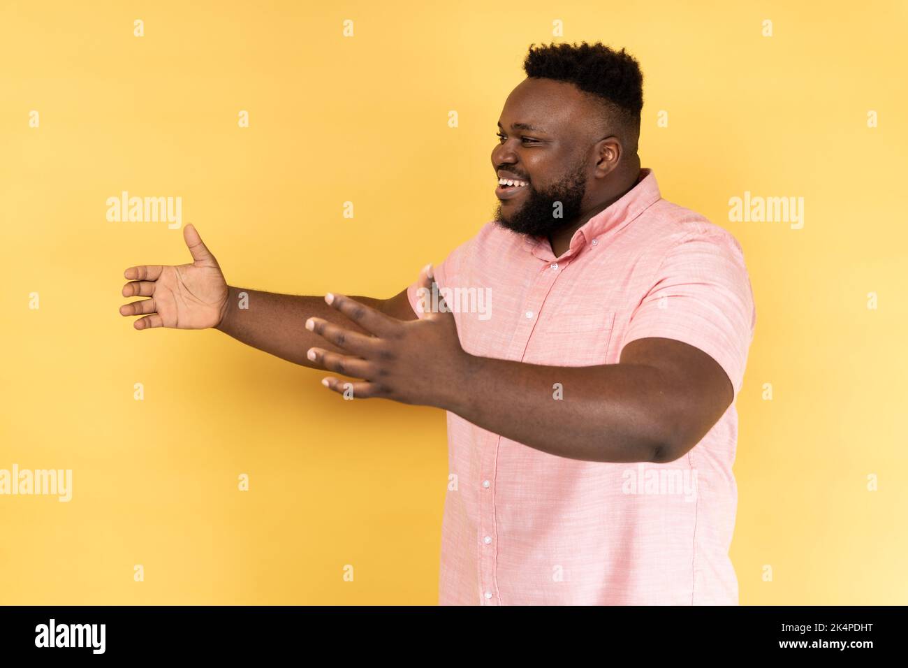 Come into my arms. Side view of friendly man in pink shirt giving free ...