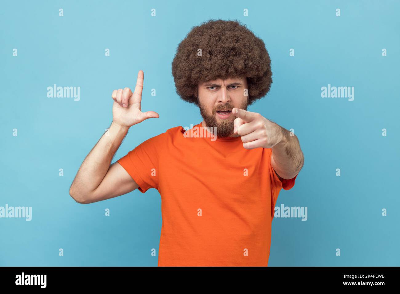 Portrait of man with Afro hairstyle wearing orange T-shirt showing ...