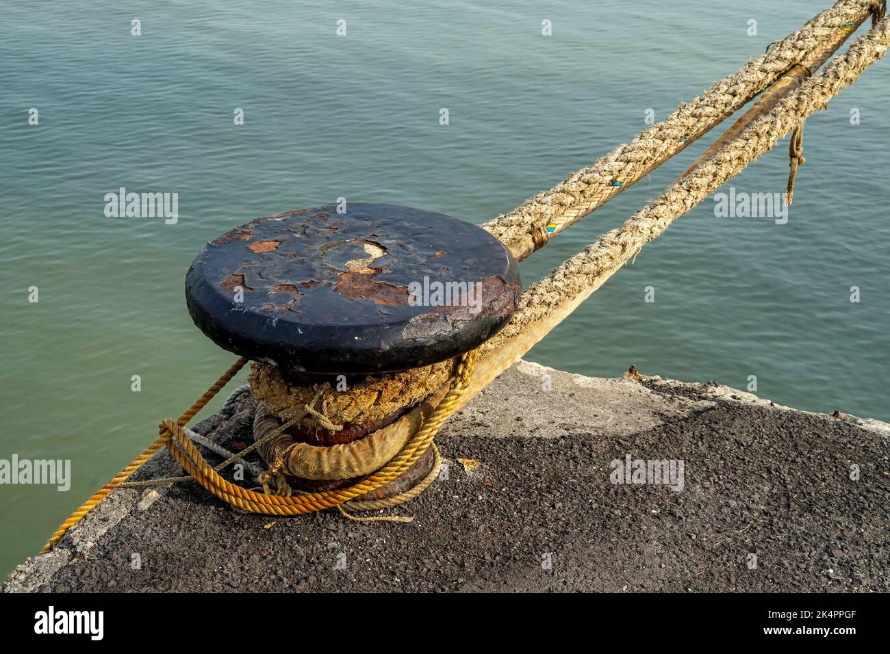 Mooring rope and bollard on sea water background in Indonesia Stock ...