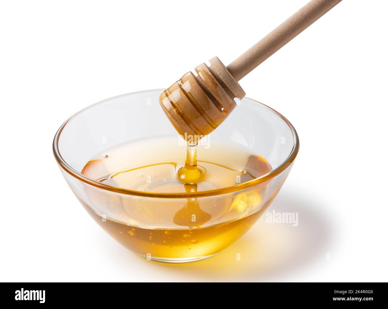 Honey and honey dippers in glass bowl on white background. Honey drips ...