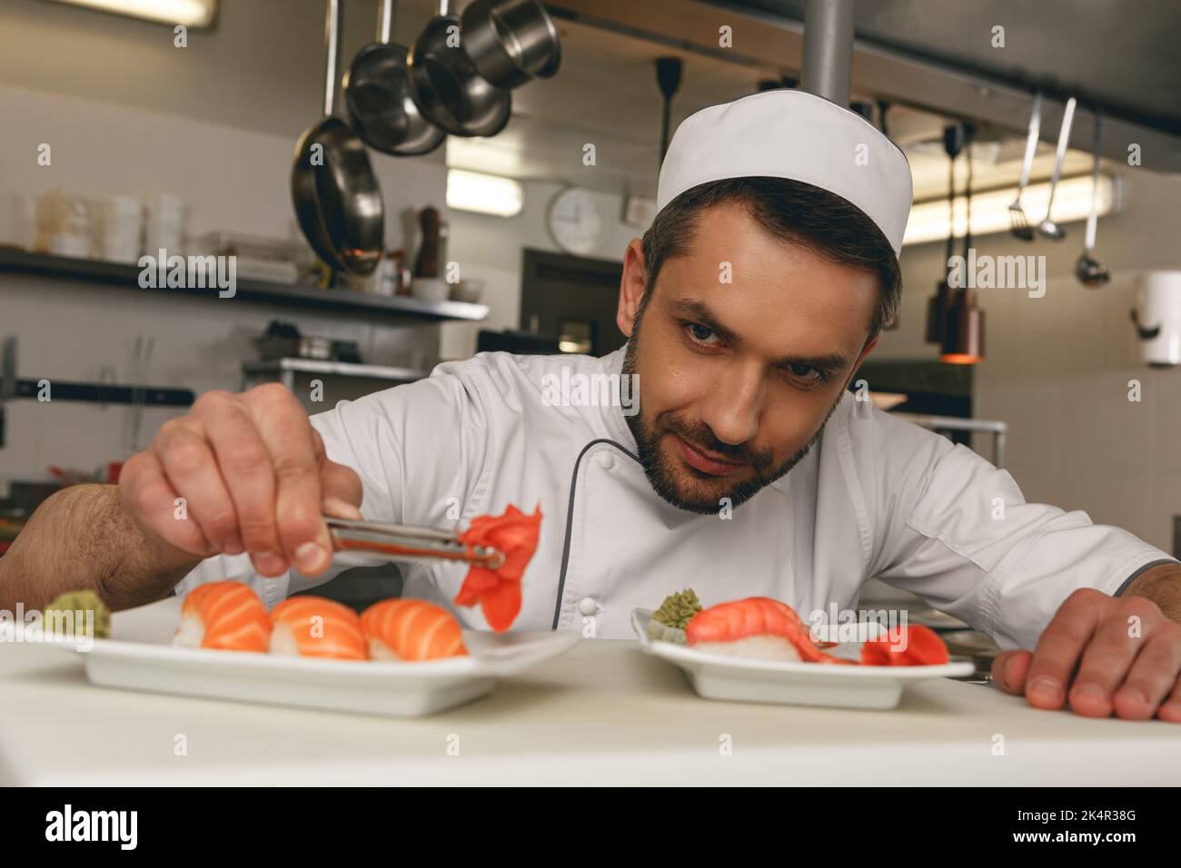 Sushi master prepares sushi for serving in modern commercial kitchen ...