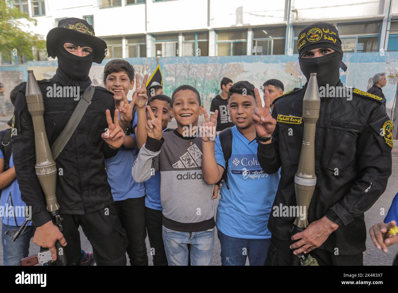 Palestinian children pose for photos with the armed fighters from ...
