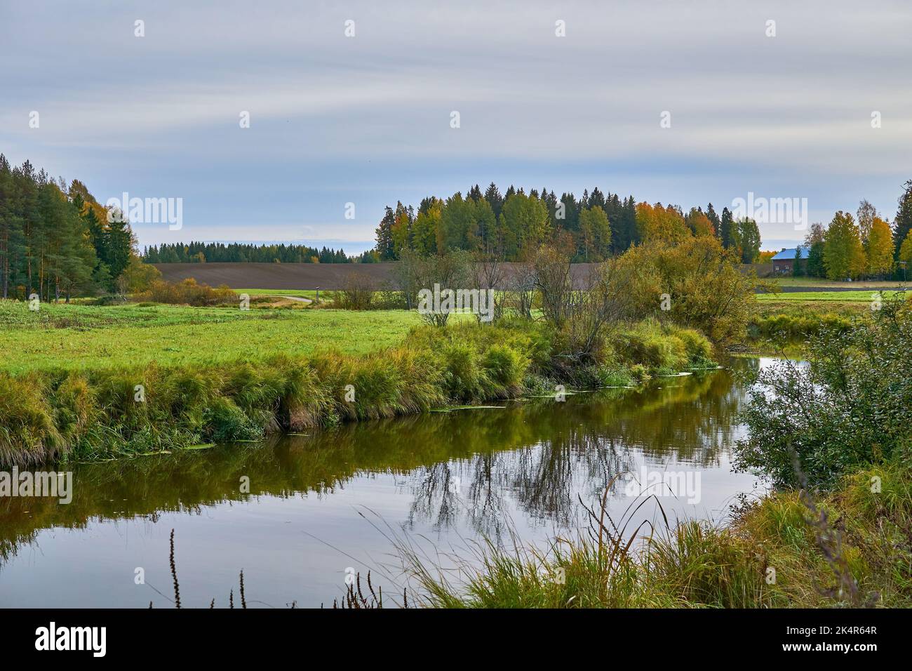 A peaceful scene of a river surrounded by foliage in fall colors Stock ...