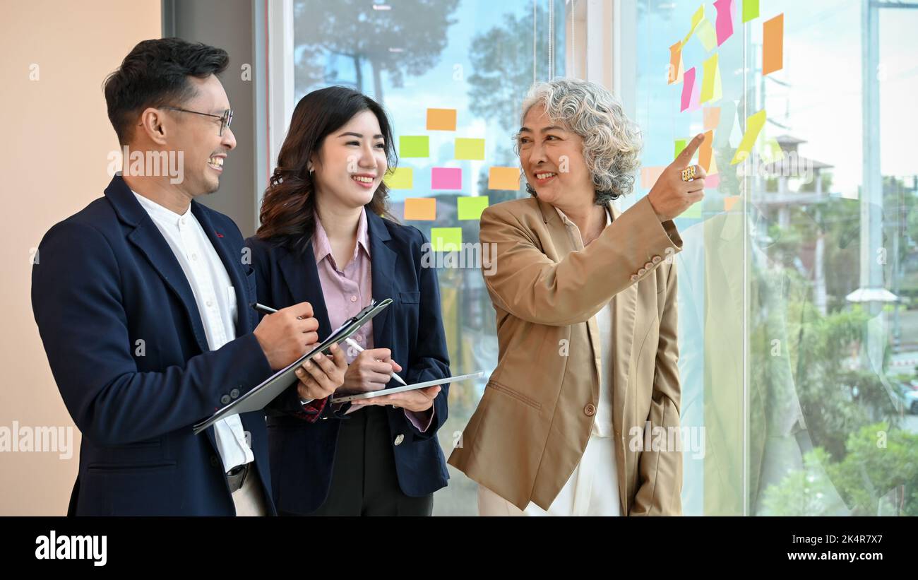 Professional and cheerful senior Asian female boss training and giving ...