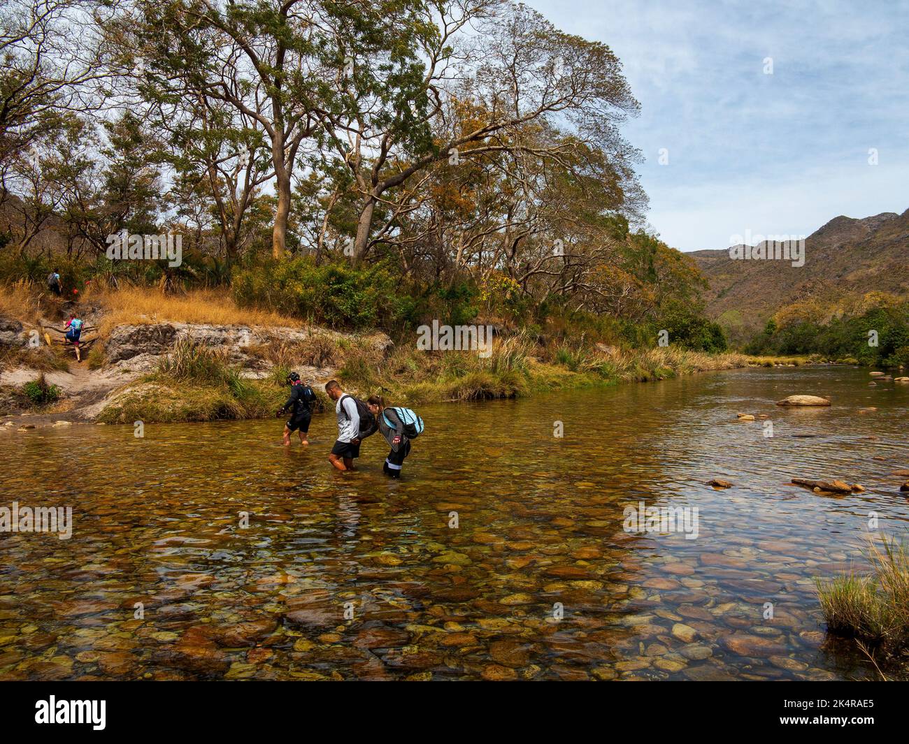 Tourists crossing the Mascates stream on the way to Bandeirinhas Canyon ...