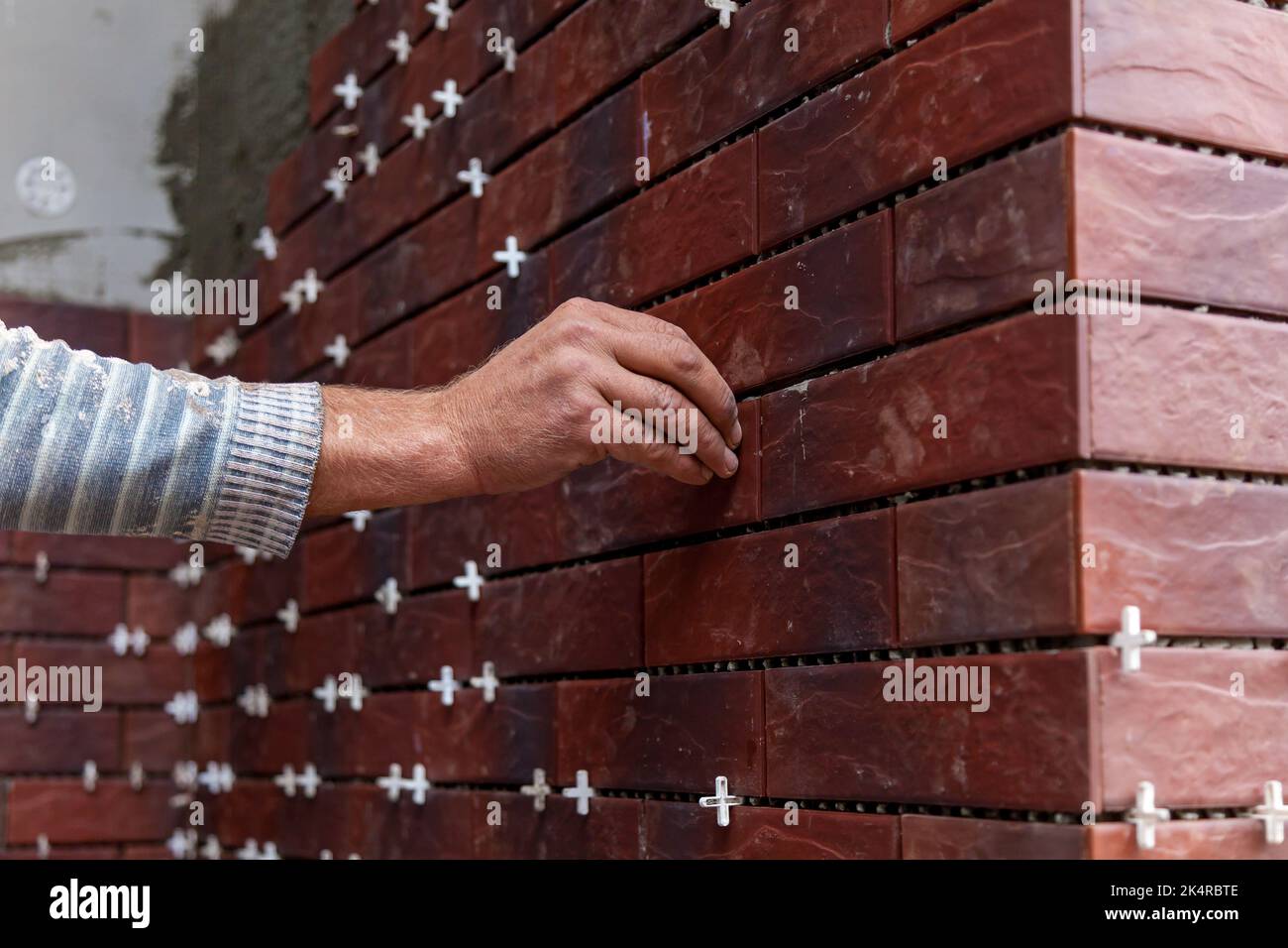 Installation of facing facade tiles on the wall of the house Stock ...