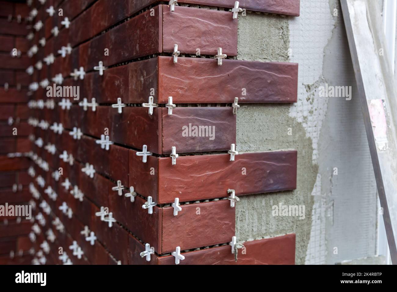 Installation of facing facade tiles on the wall of the house Stock ...
