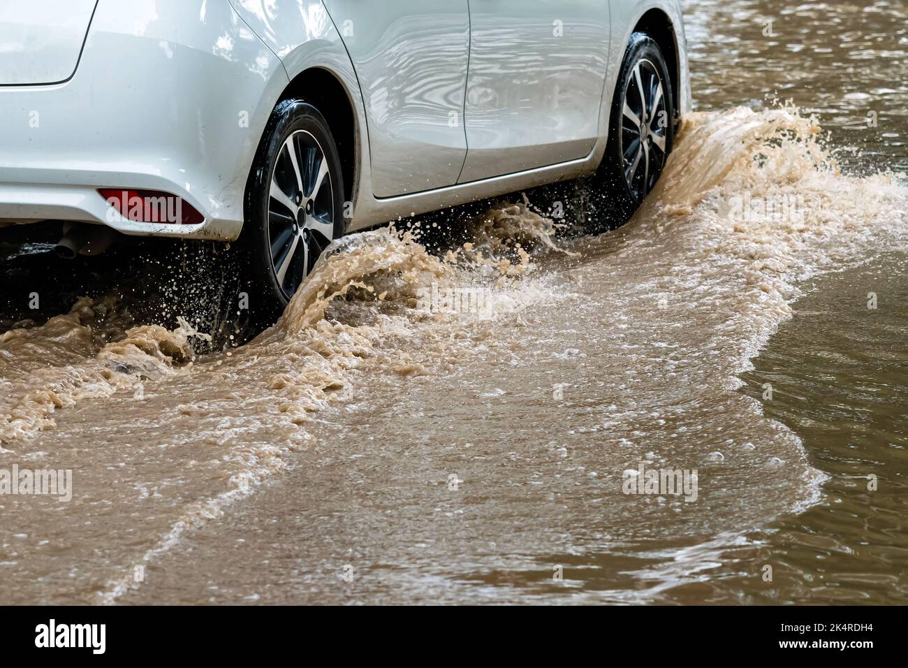 Car passing through a flooded road. Driving car on flooded road during ...