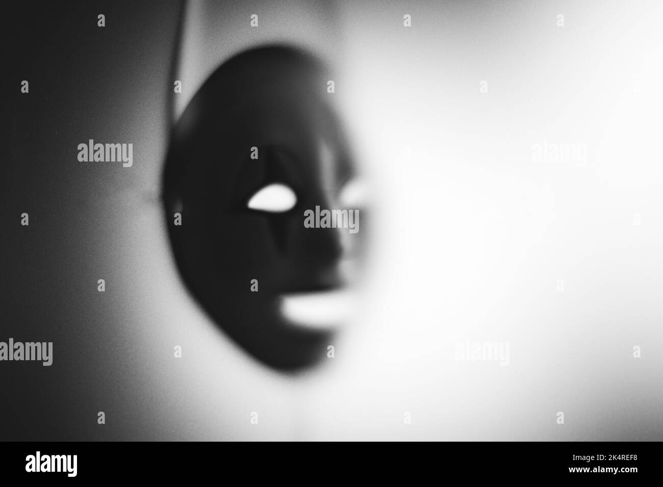 Horror face mask behind the matte glass. Halloween festival concept ...