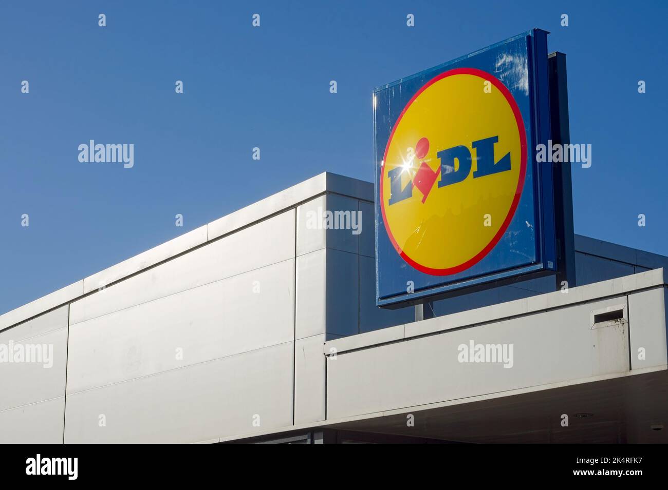 Close-up of Lidl supermarket sign with sun reflection on a blue sky ...