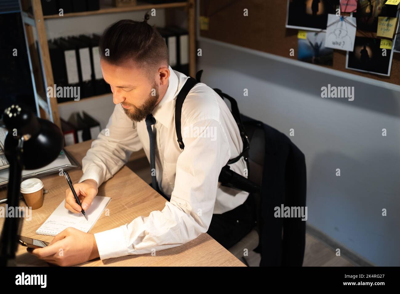 professional detective works on a murder in the office at night. He ...