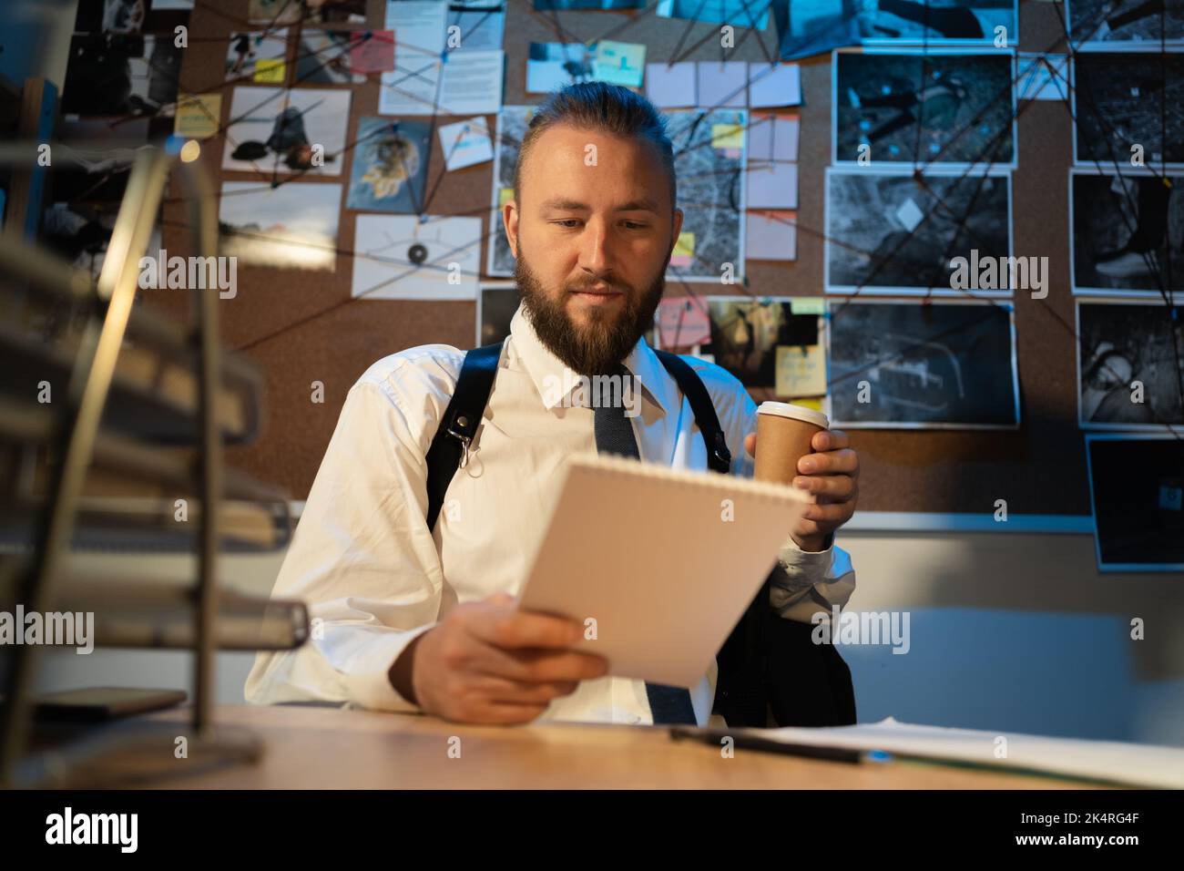 A professional detective is working on a murder in the office at night ...