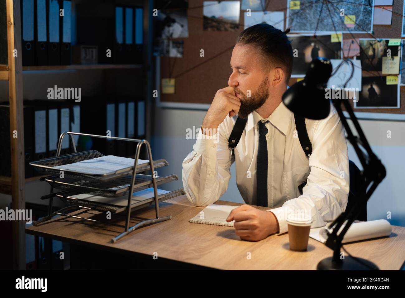 Detective working at desk in his office, investigator analyzing crime ...