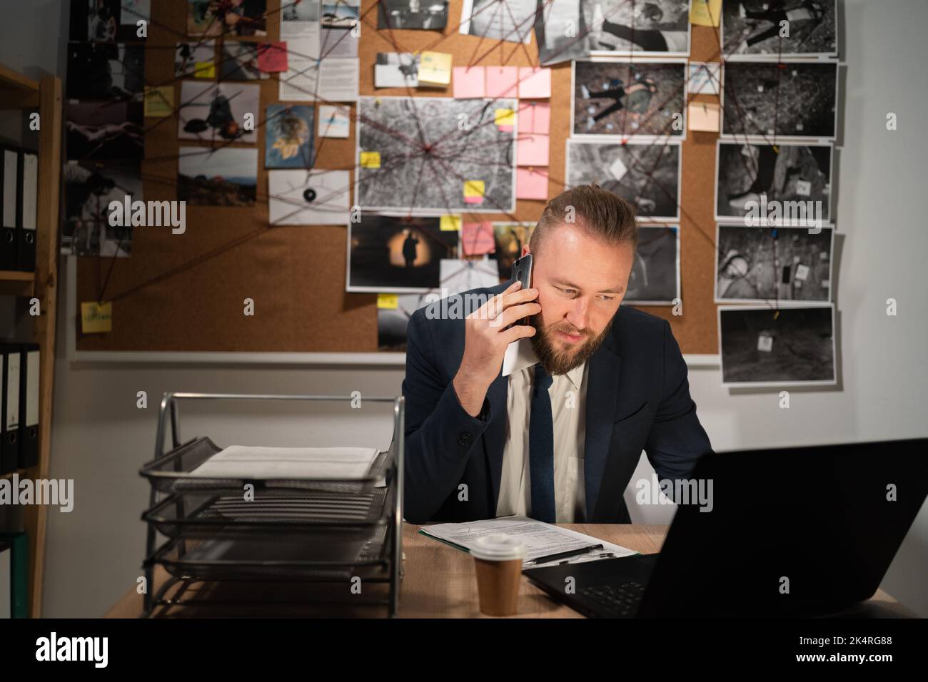 young detective sitting at police department talking to colleague on ...