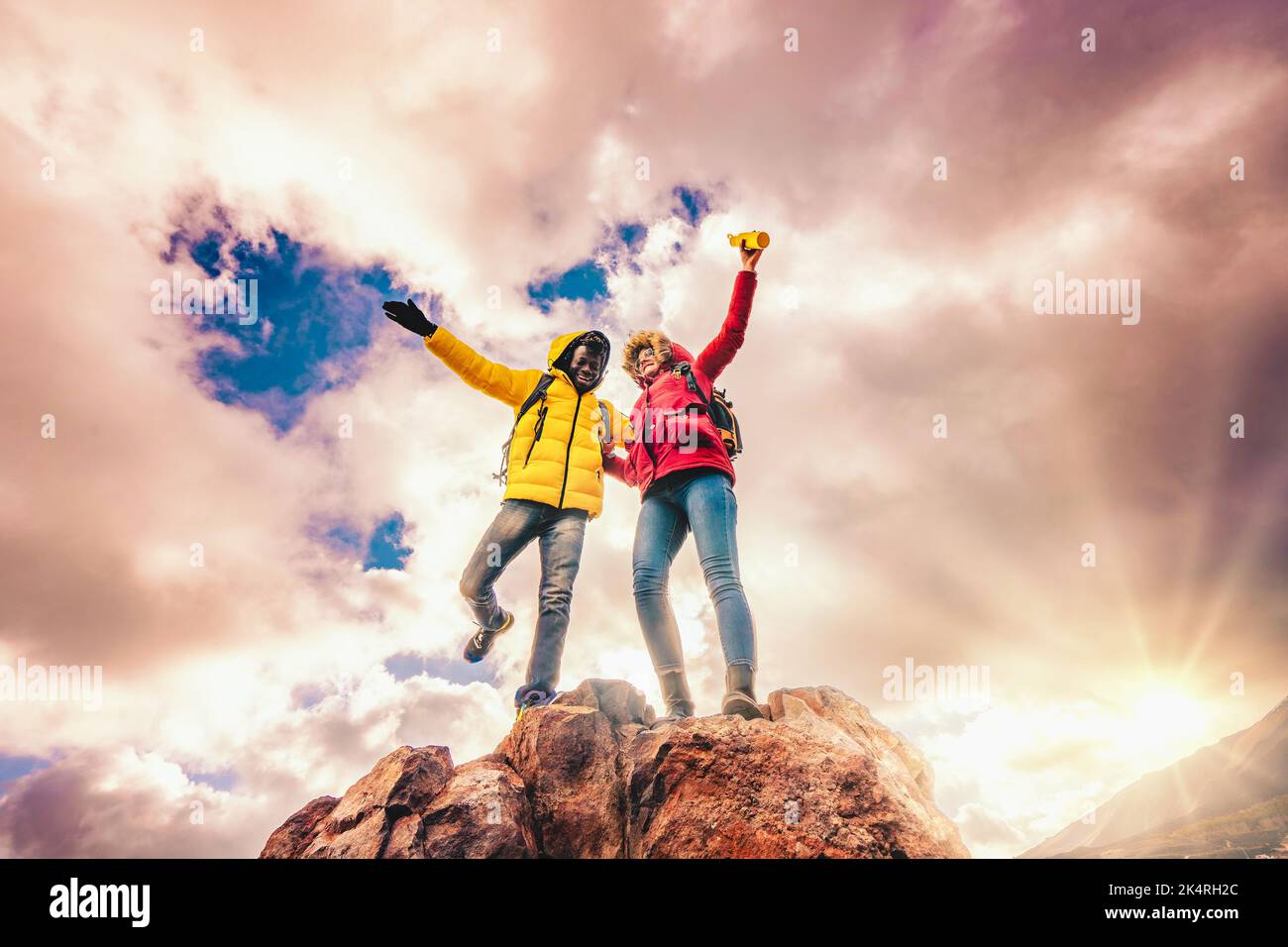 Couple of. young hikers exulting at the top of the mountain arms up ...