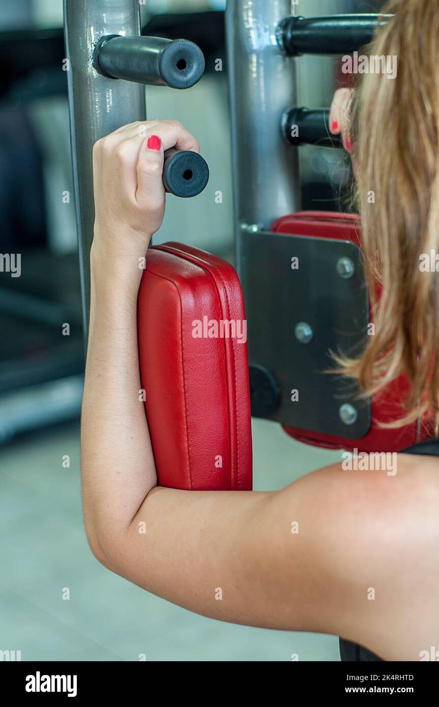 Arms exercising on a chest machine at the gym. Woman Stock Photo - Alamy