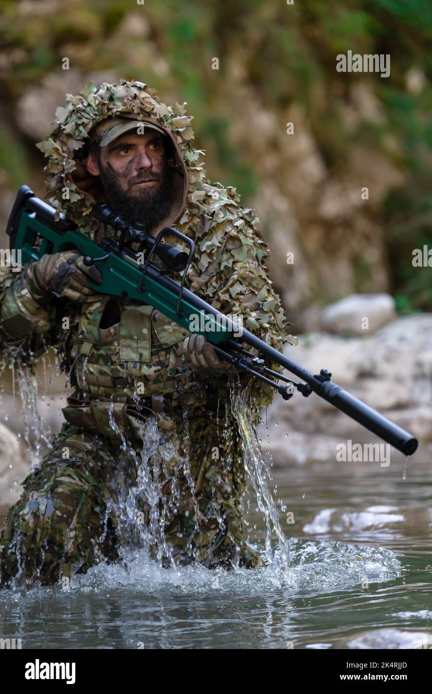 A military man or airsoft player in a camouflage suit sneaking the ...